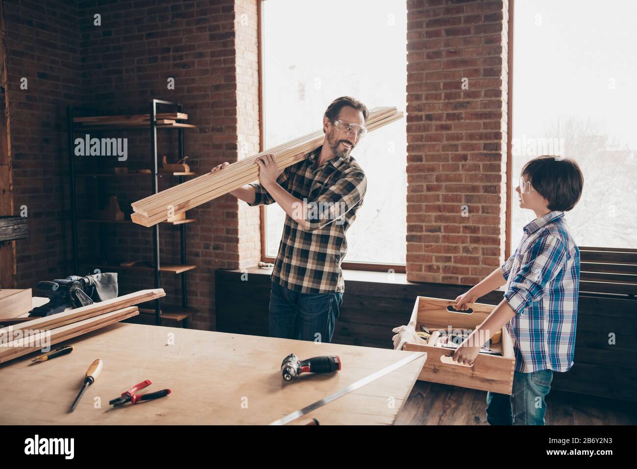 Two nice cheerful cheery hard-working person master builder hard ...