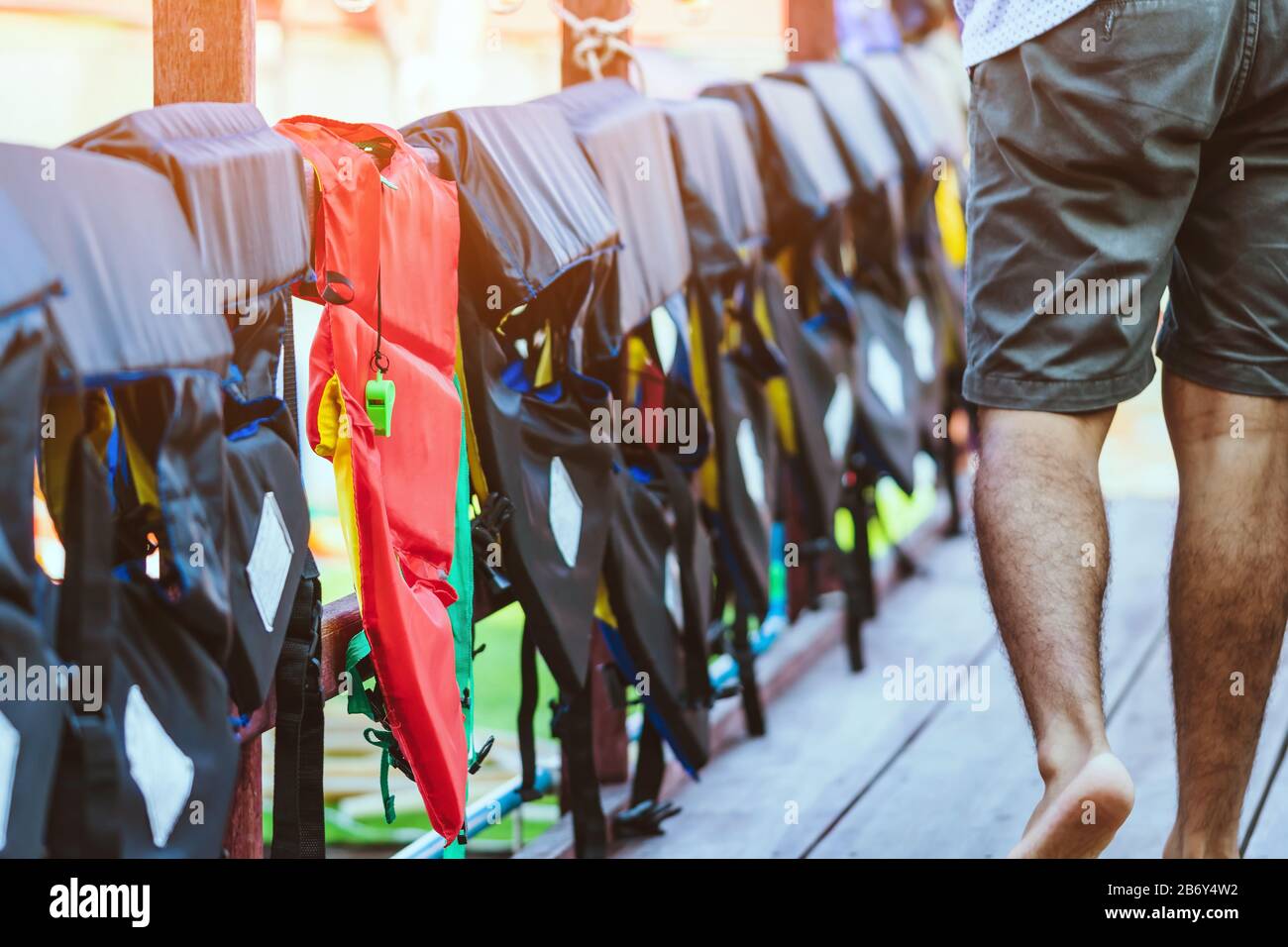 A green whistle with red life jacket hanging on the railing around the ...