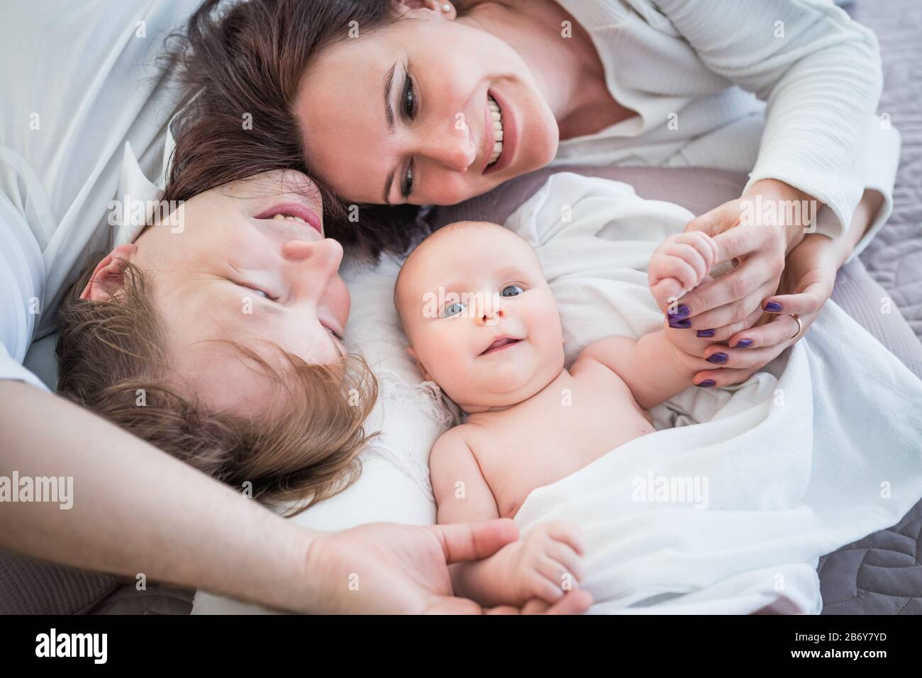 Top view happy positive Young family husband wife and little newborn ...