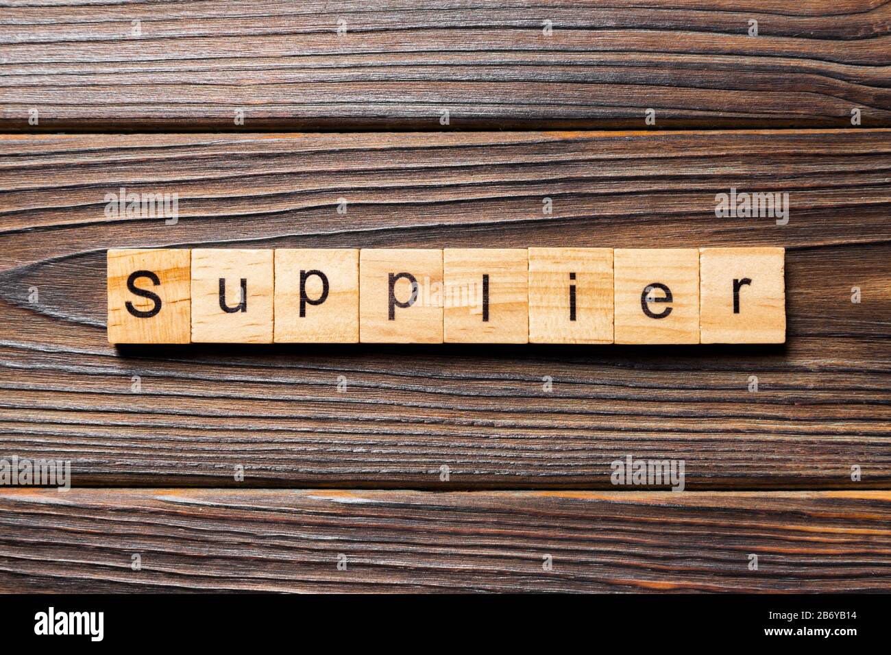 SUPPLIER word written on wood block. SUPPLIER text on wooden table for ...