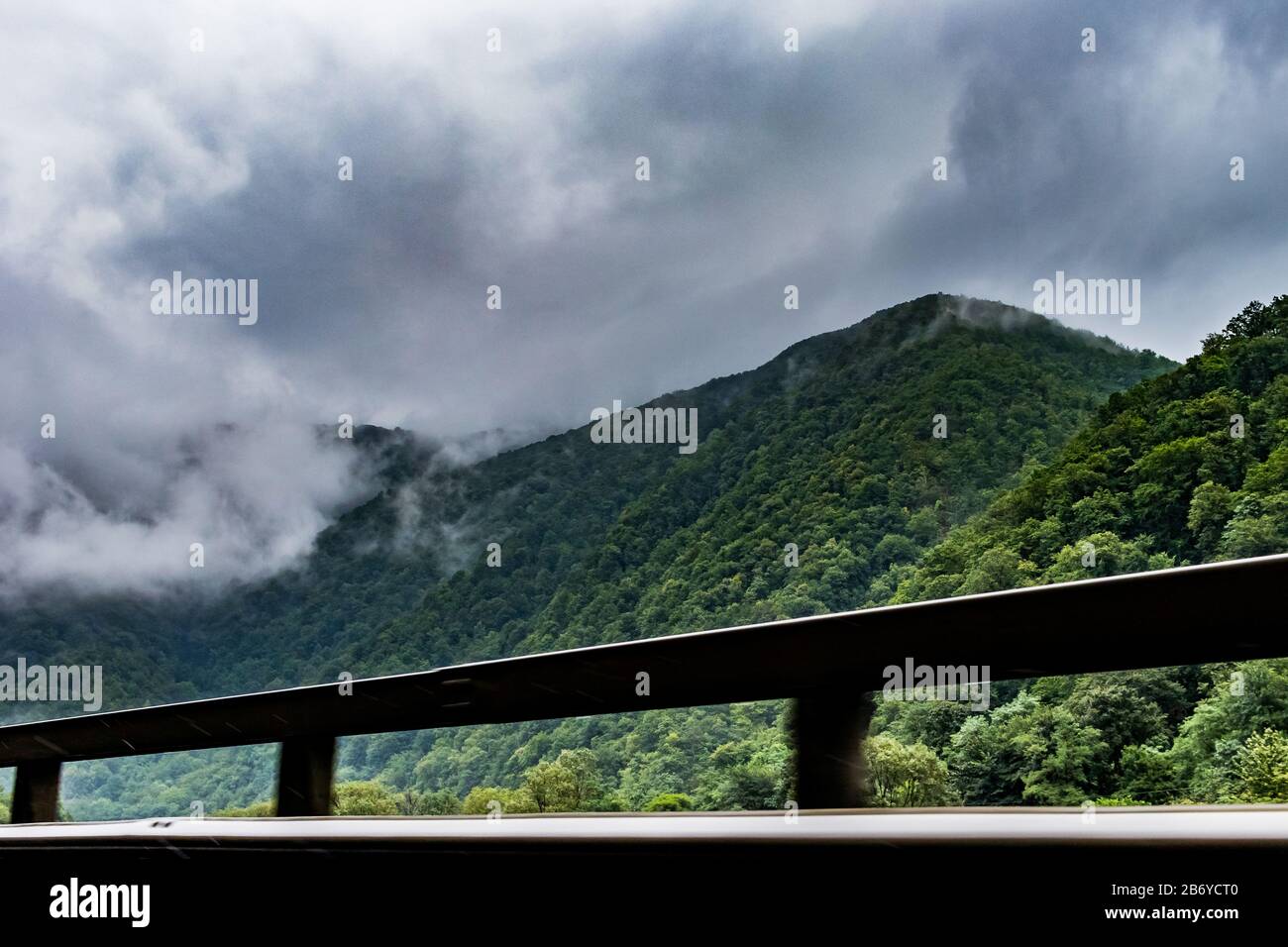 Mountain road railing with foggy mountain forest in the background ...