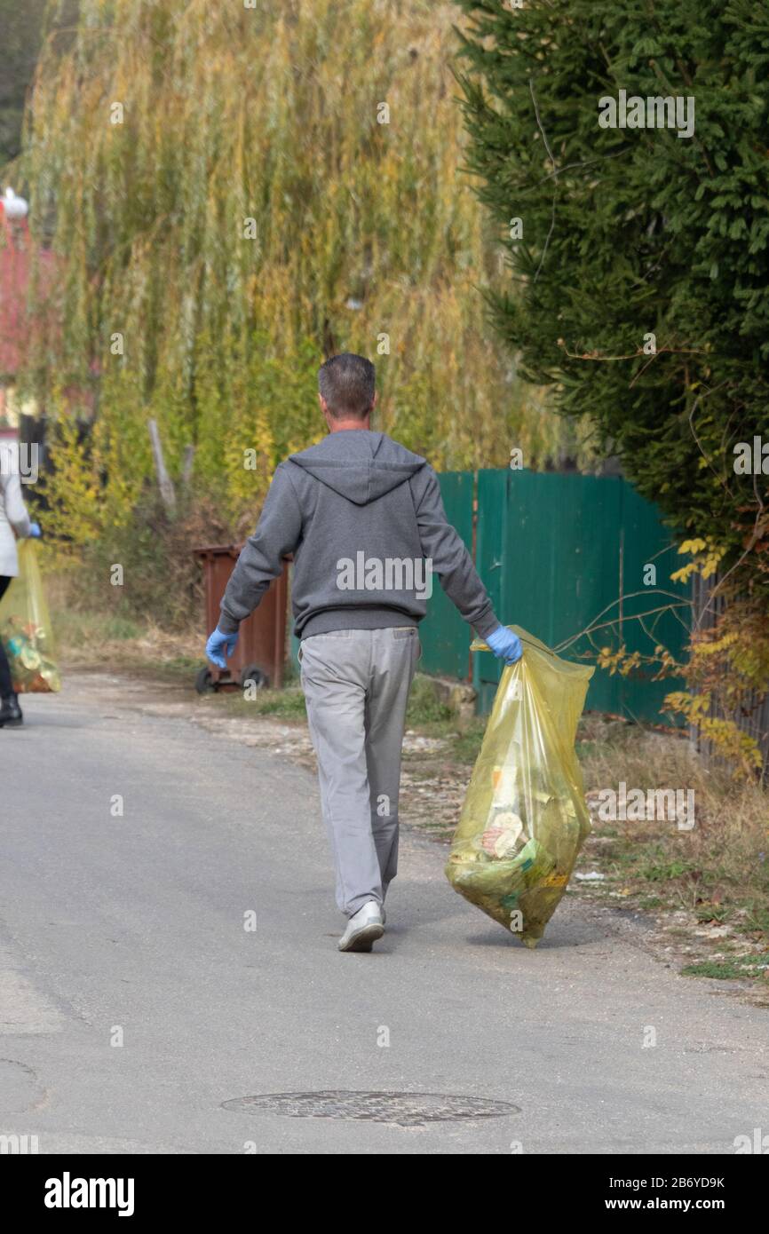 Man carrying trash bag hi-res stock photography and images - Alamy