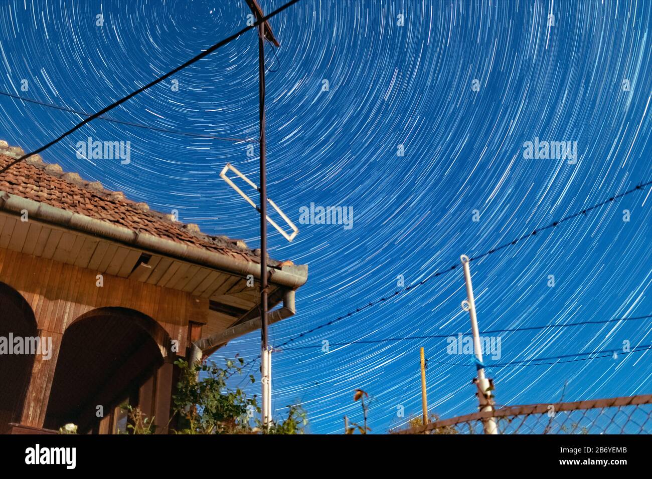 Star trails behind old house Stock Photo - Alamy