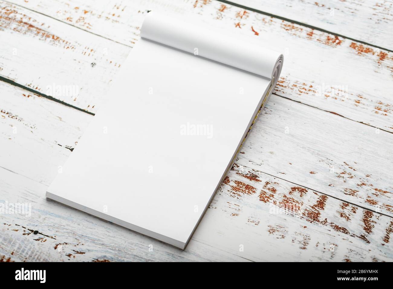 Notepad with a red pencil on a white wooden table against the ...