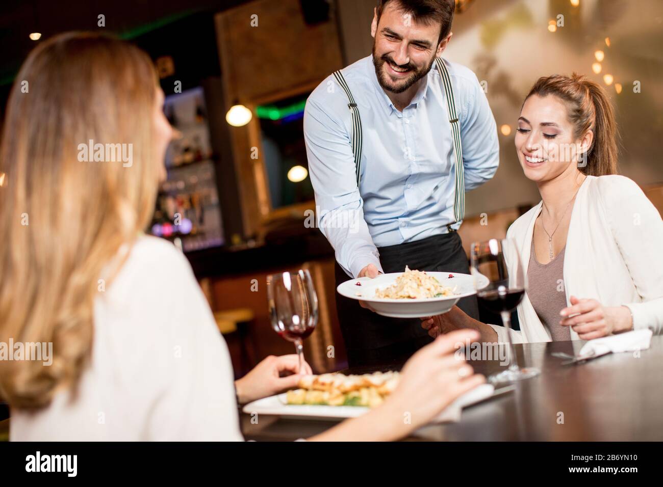 The waiter carries dishes in modern restaurant Stock Photo - Alamy