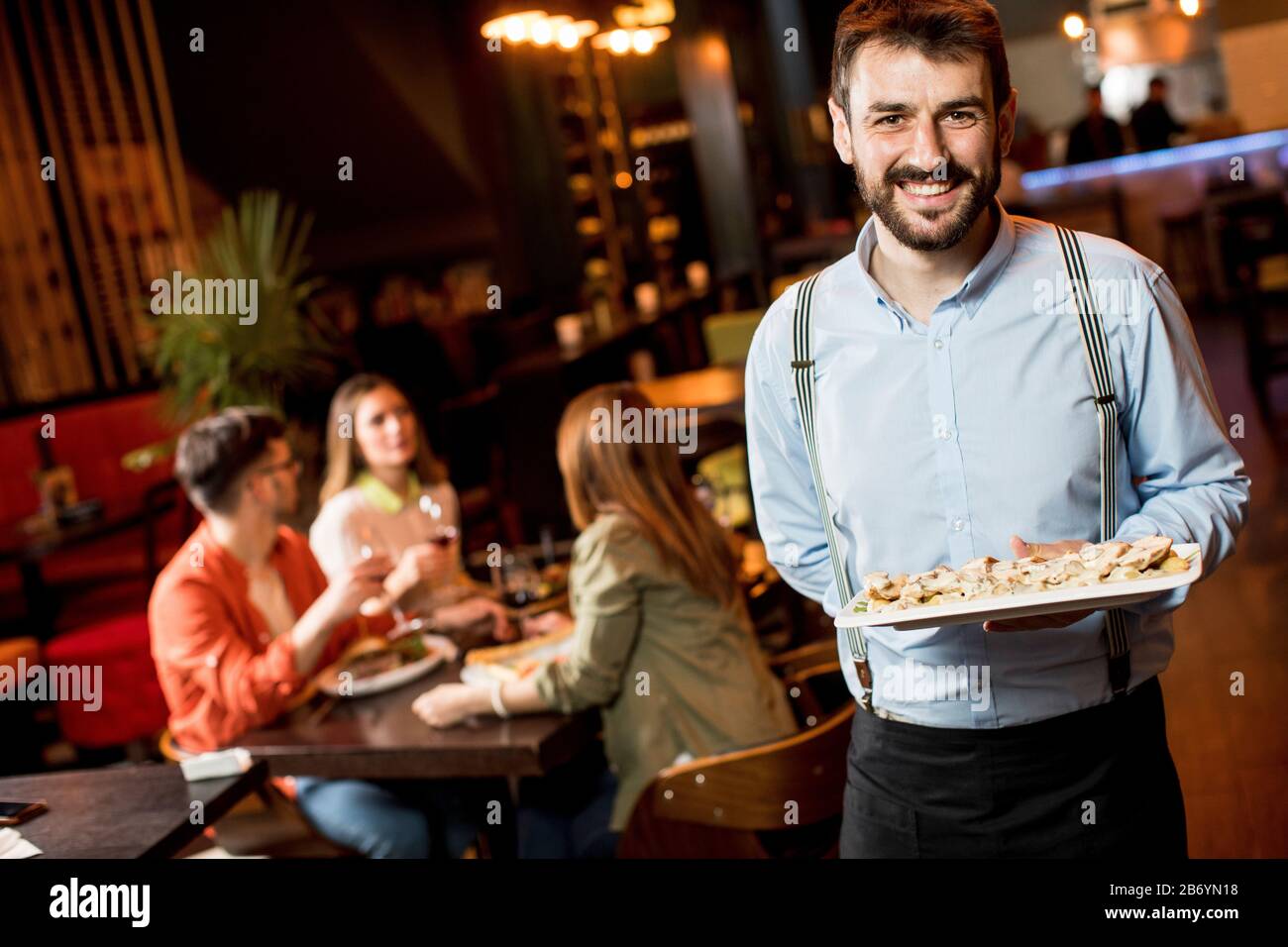 Portrait of the waiter carries dishes in modern restaurant Stock Photo ...