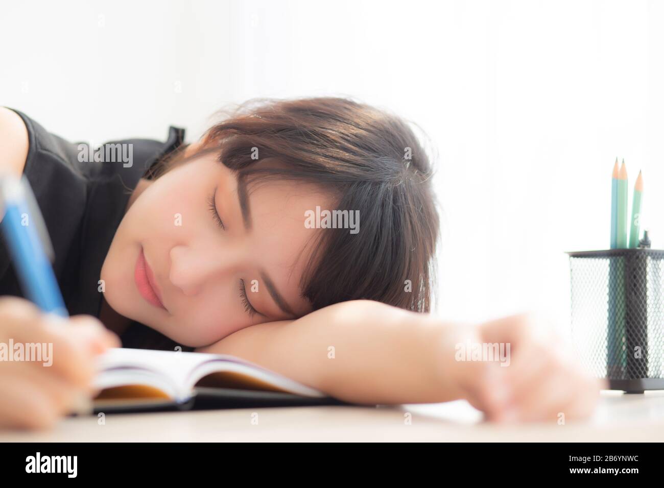 Beautiful portrait young asian woman smile and happy writing learning ...