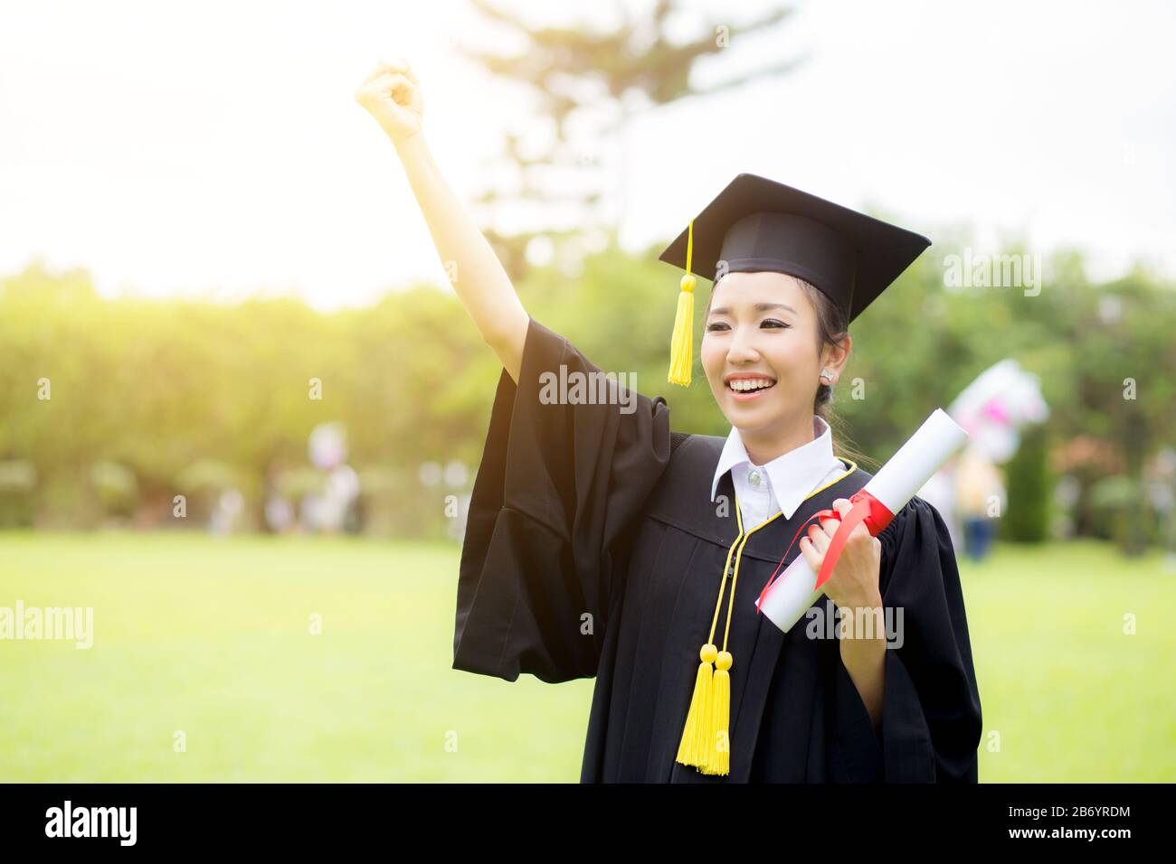 Graduate woman students wearing graduation hat and gown Stock Photo - Alamy