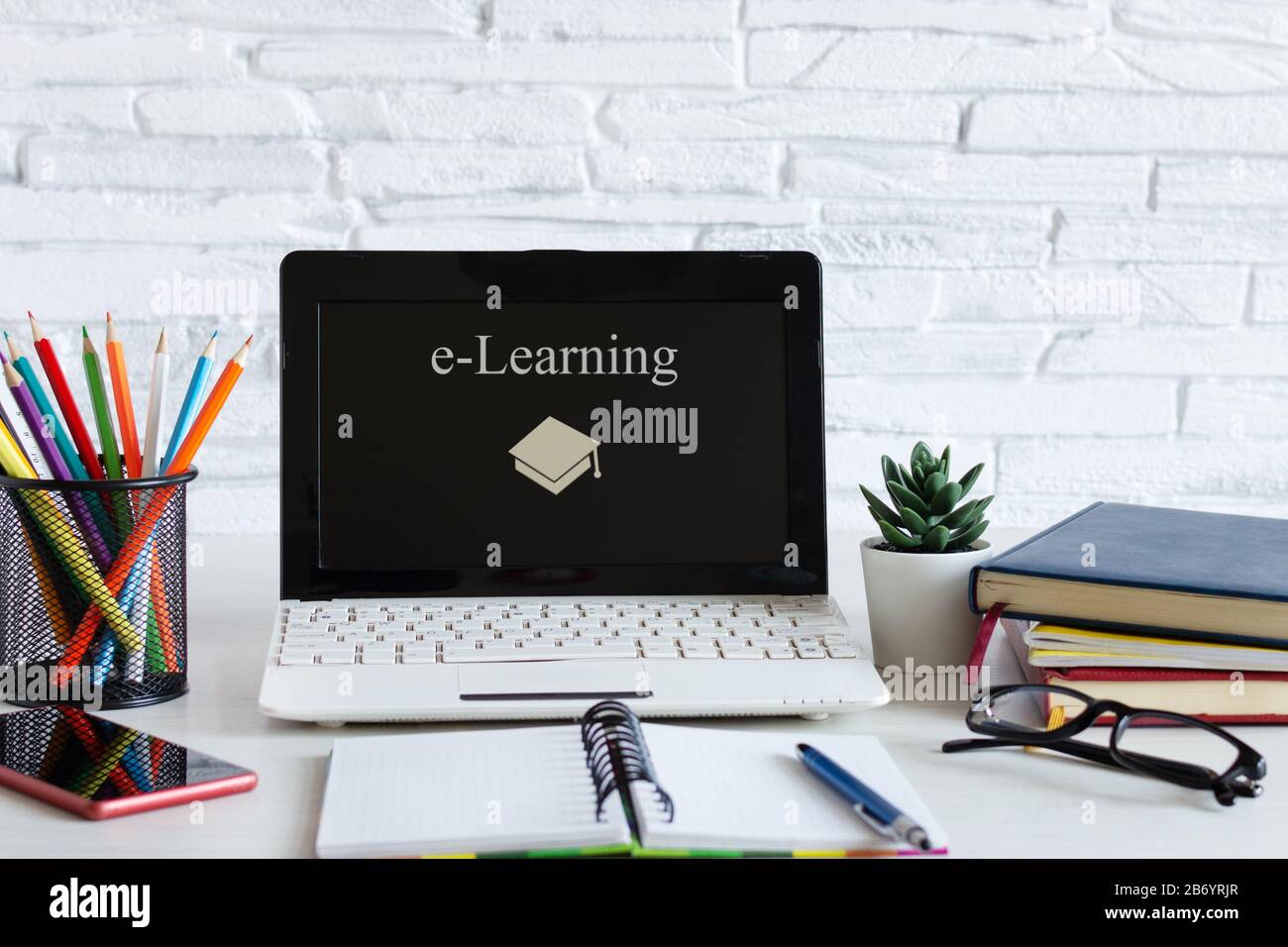 Workplace with laptop and books. E-learning, online education concept ...