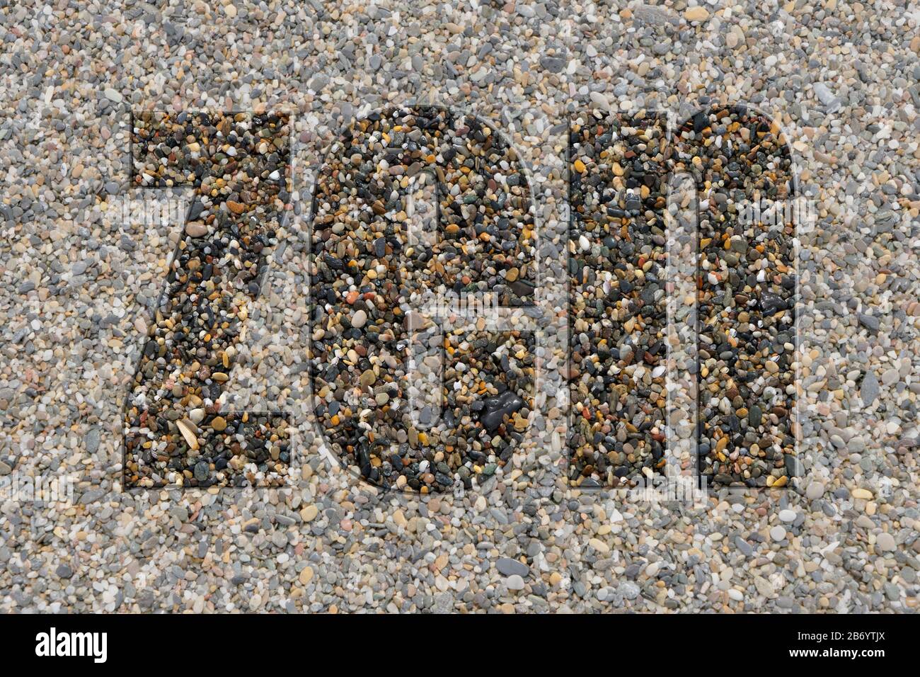 Texture of small boulders of a beach in gray tones with the word Zen ...