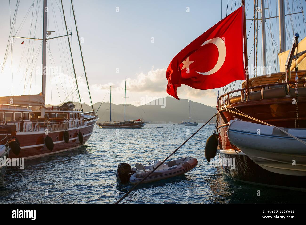 Beautiful wooden yacht with the big flag of Turkey on the pier, against ...