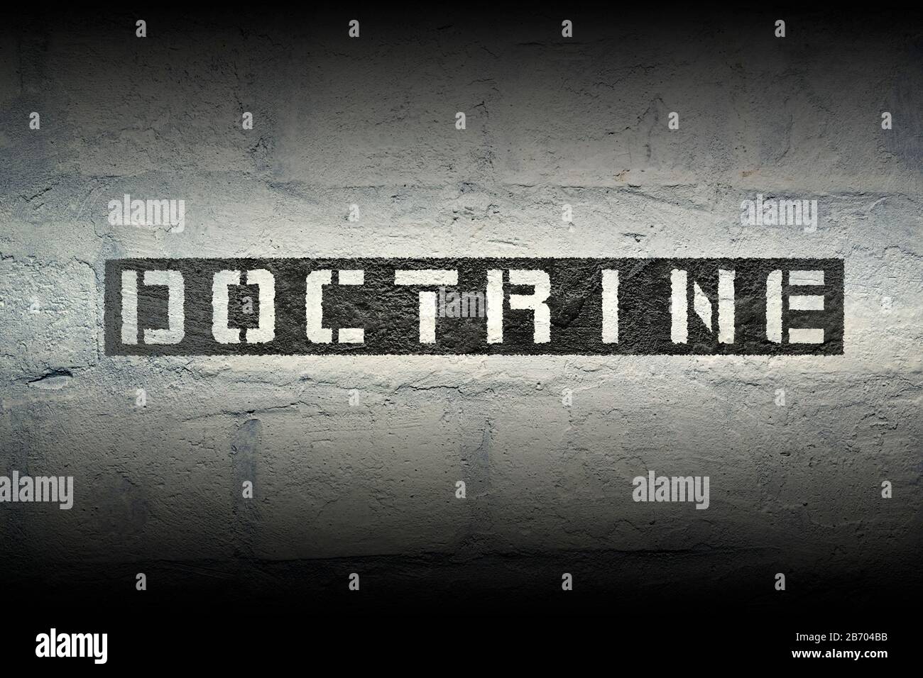 doctrine word stencil print on the grunge white brick wall Stock Photo ...