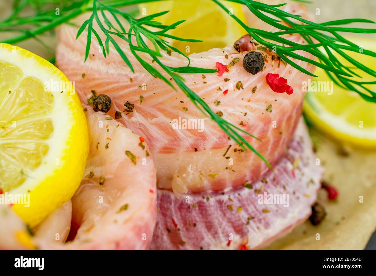 fish fillets of dogfish with lemon herbs on black background Stock ...