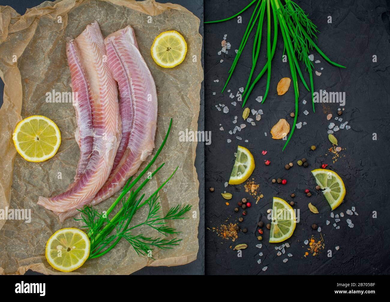 fish fillets of dogfish with lemon herbs on black background Stock ...
