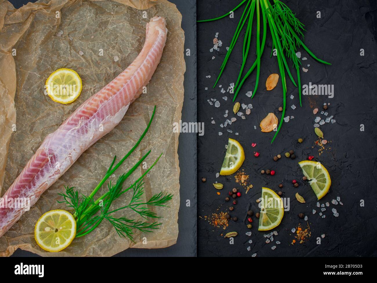 fish fillets of dogfish with lemon herbs on black background Stock ...