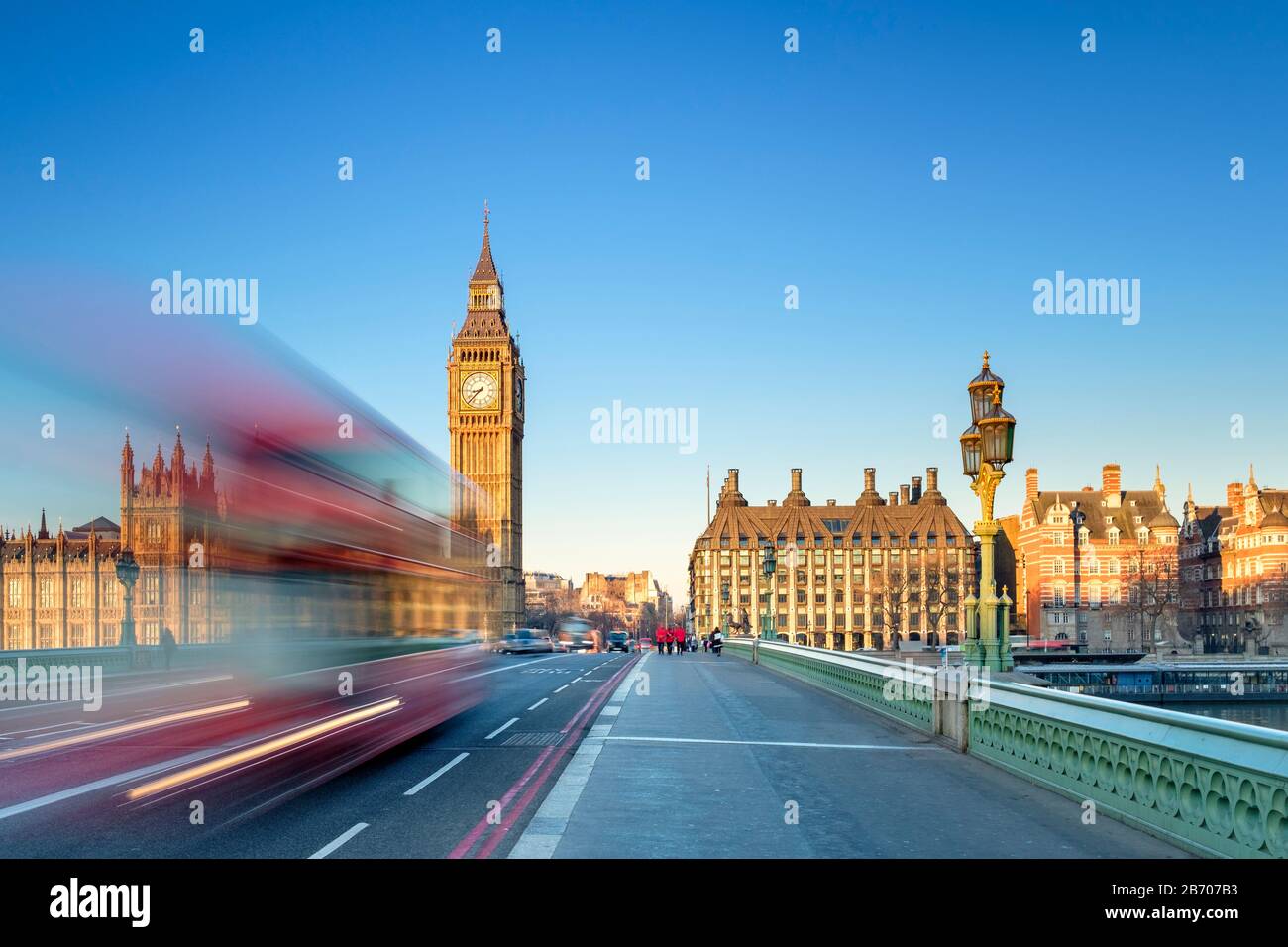 Red double-decker bus passes on Westminster Bridge, in front of ...