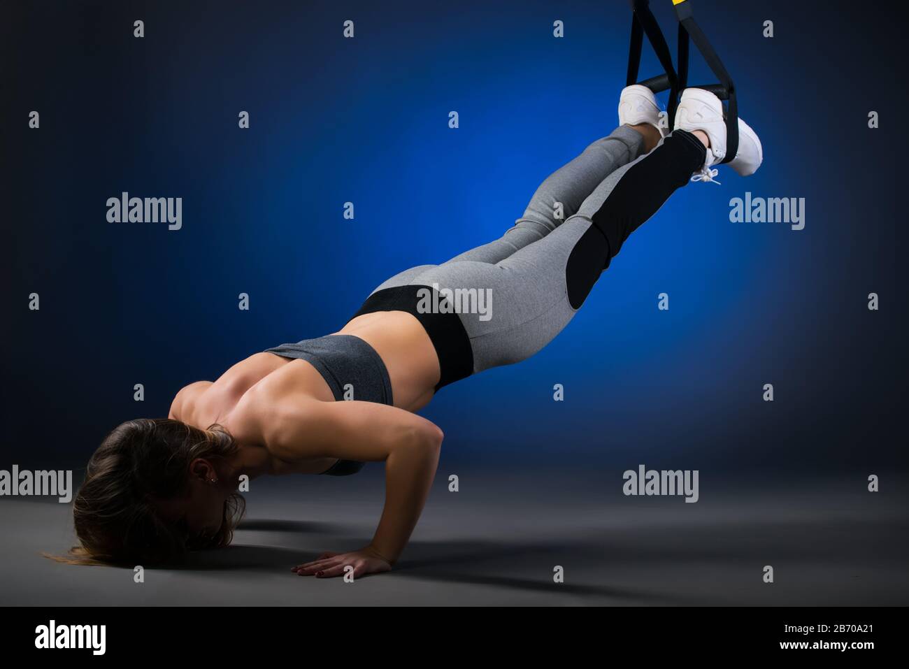 Charming young long-haired positive Caucasian fitness model doing push ...