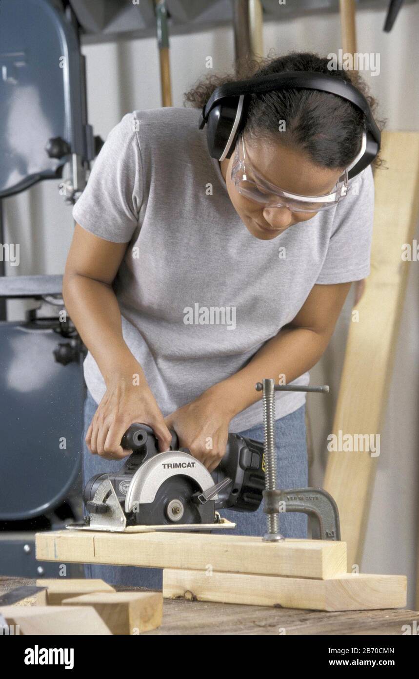 Austin, Texas USA, 1998: African-American woman uses cordless circular ...