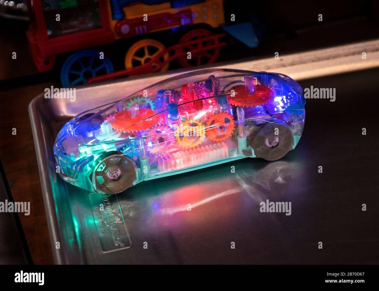 Toy Car with colorful flashing lights moving around in a tray in a ...