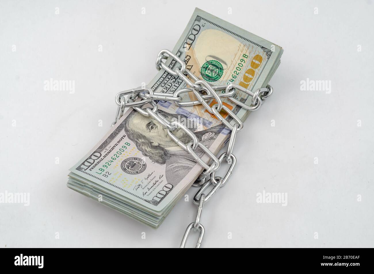 Bundle of American dollars rewound with a metal shiny chain. Isolate on ...
