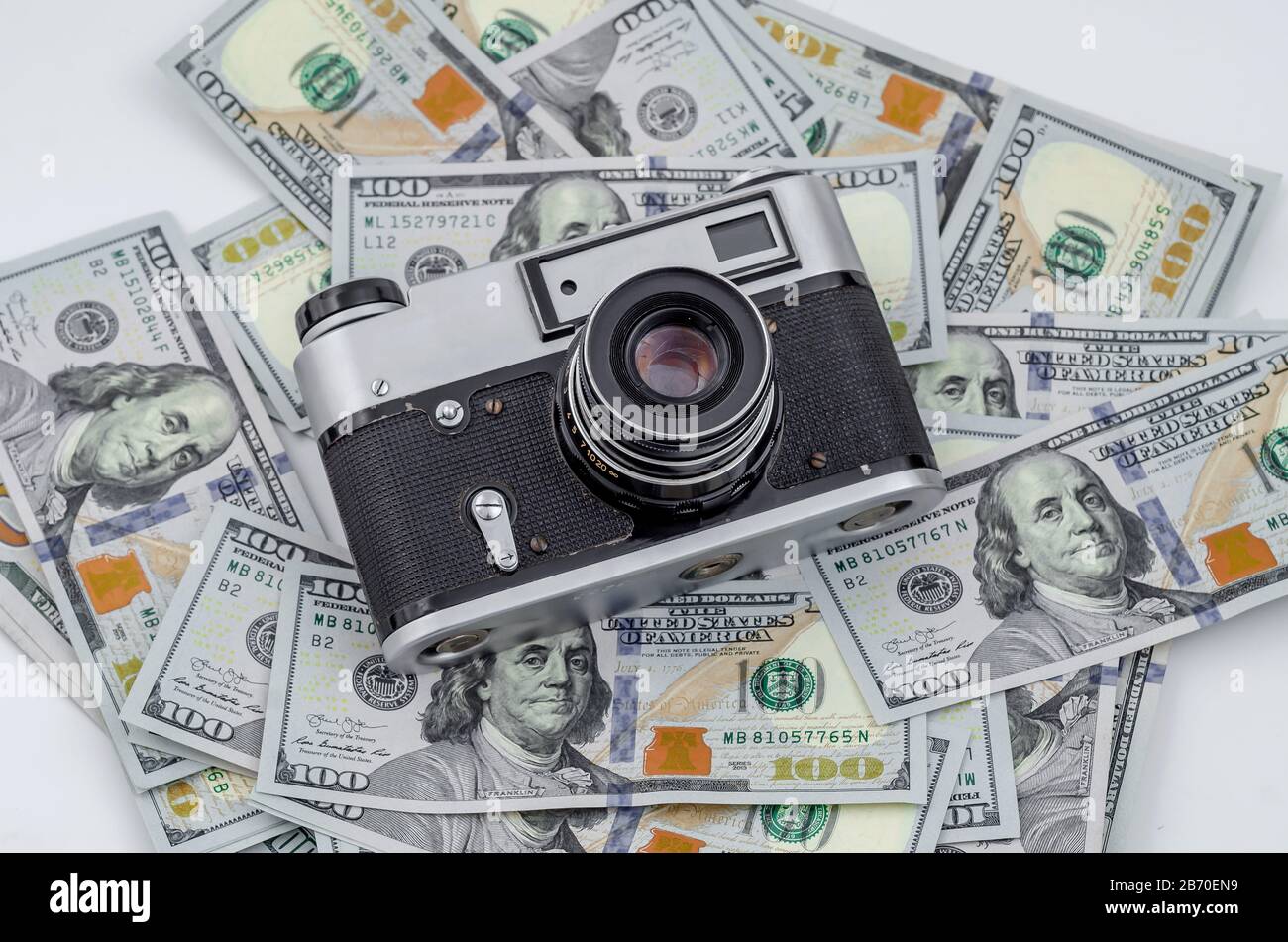 Vintage film camera on scattered American dollars. Concept of earning ...