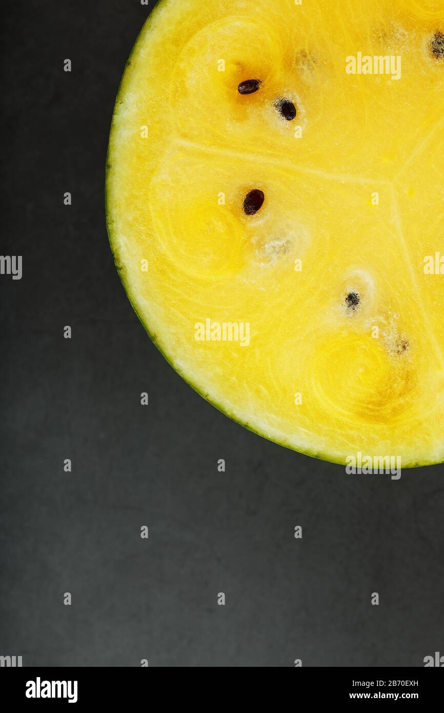 Half yellow watermelon on a black background, texture of juicy pulp of ...