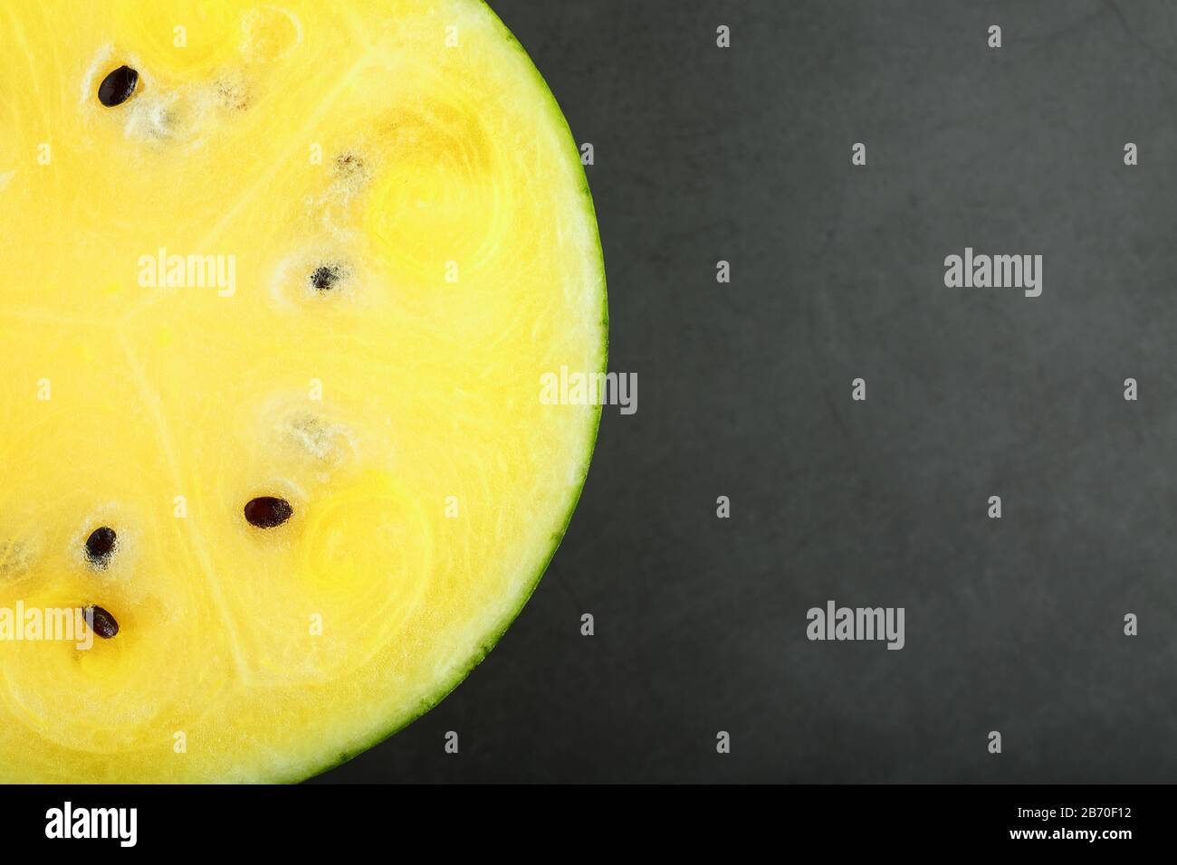 Half yellow watermelon on a black background, texture of juicy pulp of ...