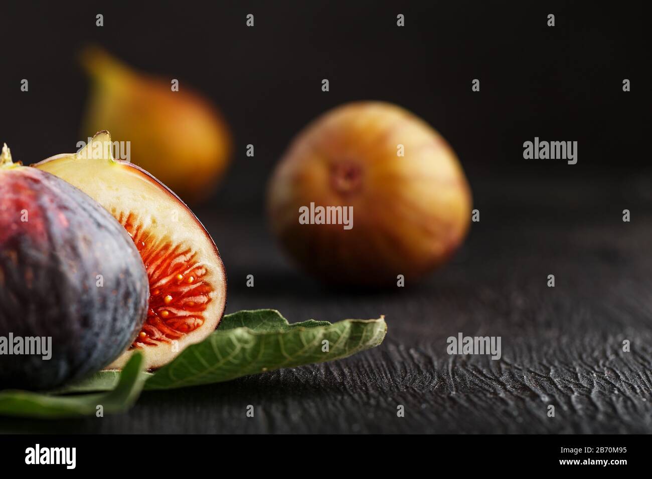 Juicy figs on a dark background, pulp of fig slices with seeds close-up ...