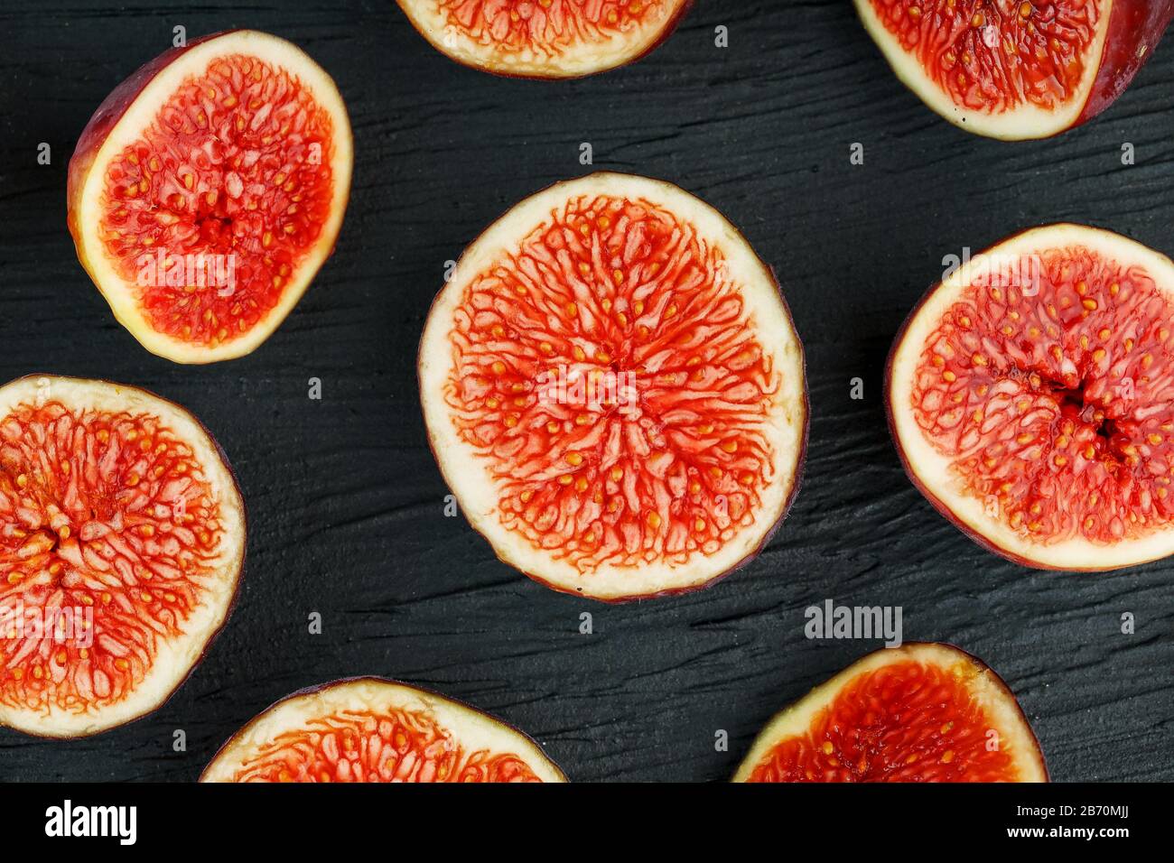 Ripe Figs. Creative diagram of chopped figs on a black textural ...