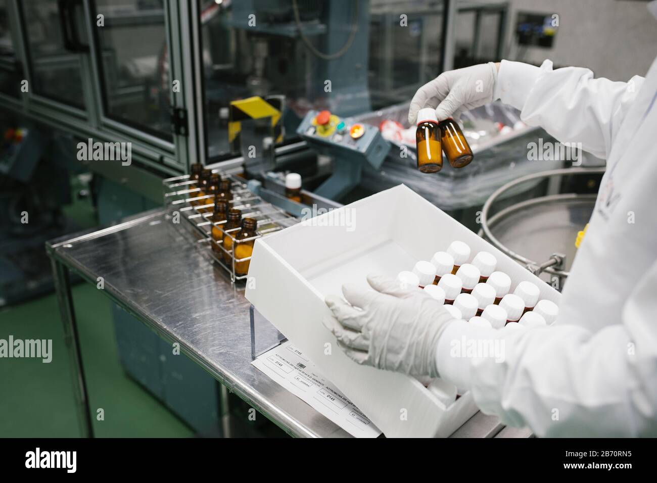 Worker in a pharma factory checking some bottles of medicine Stock ...