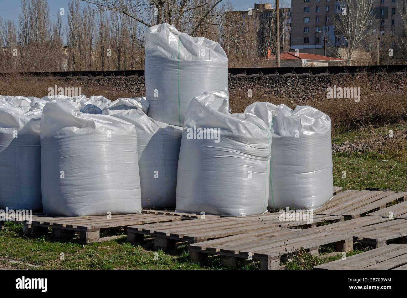 Full big bags on wooden pallets. Storage of bulk cargo in an open ...
