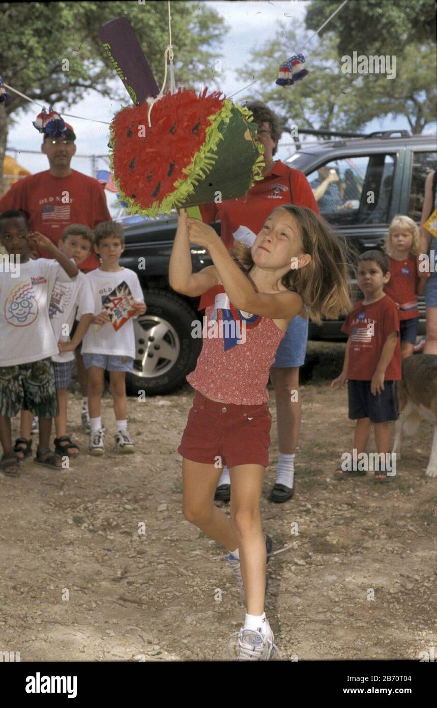 Austin, Texas USA: Seven-year-old girl swings a paddle at a watermelon ...