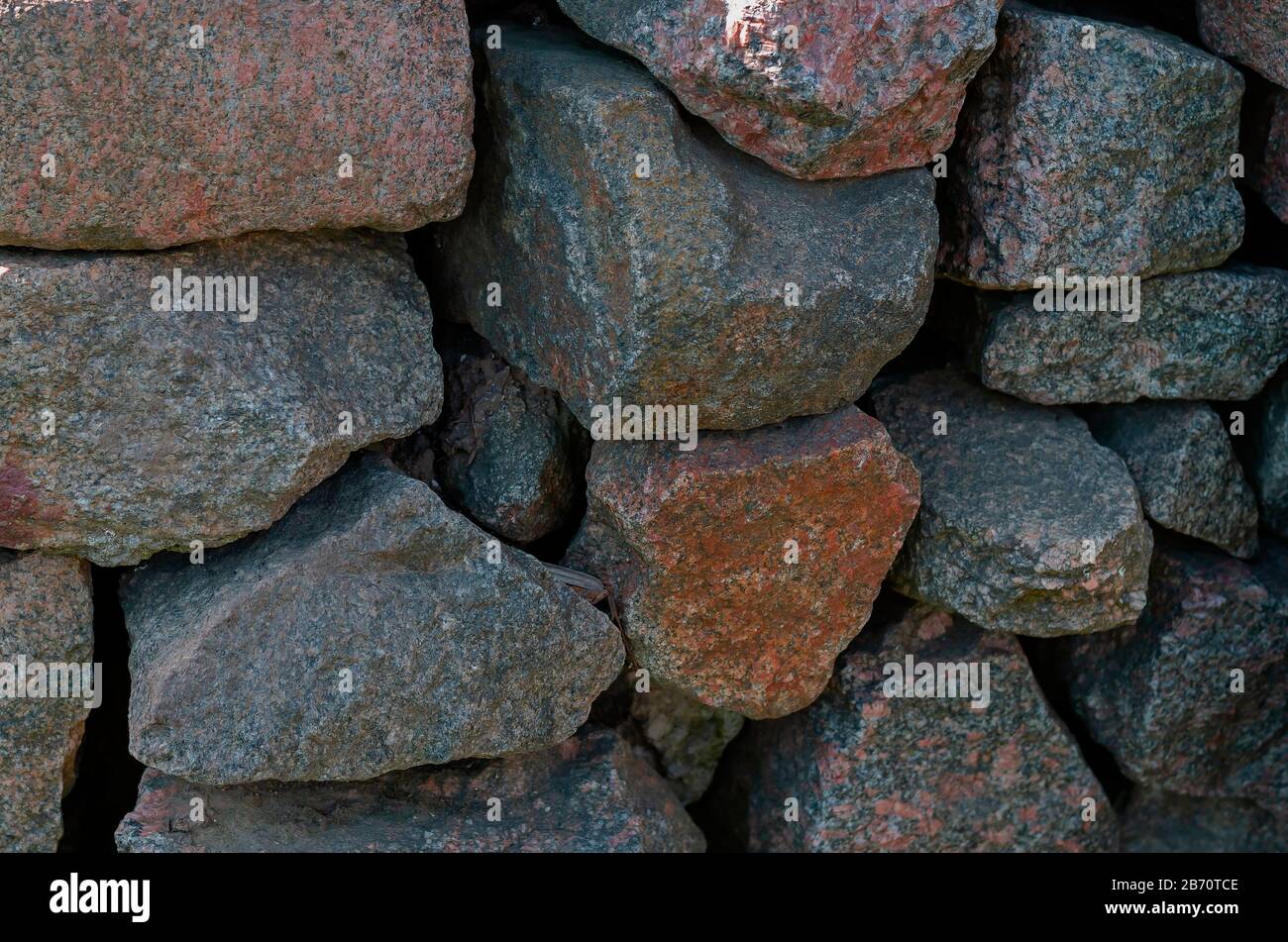 Granite stones stacked one on one. Large pieces of raw granite ...