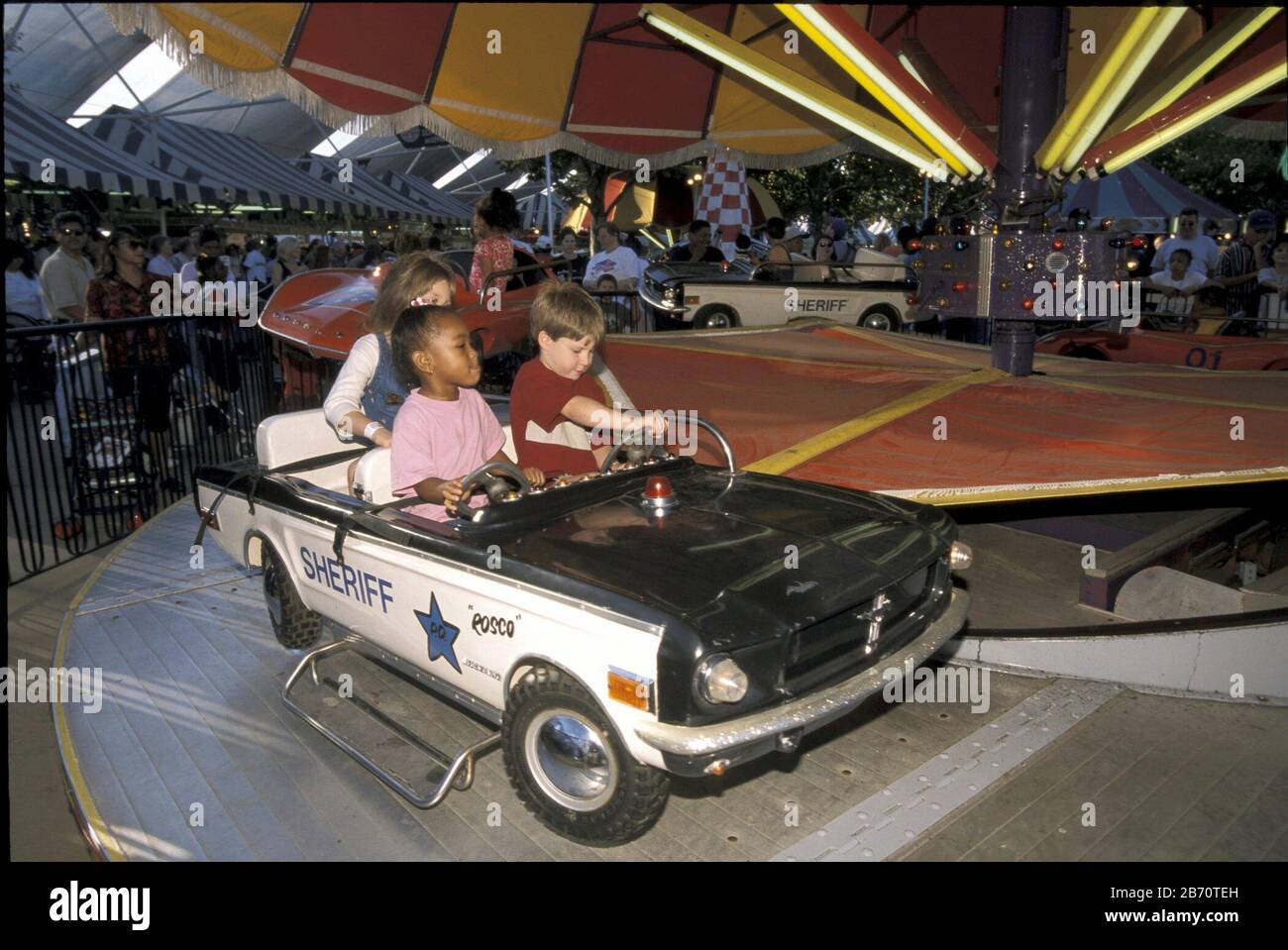 Dallas, Texas USA, 2001: Children sit on vehicle-themed carousel ride ...