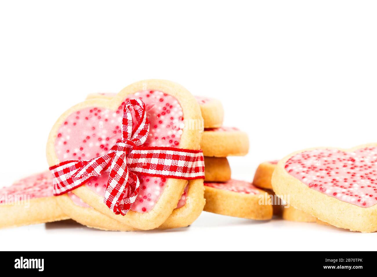 Heart shape cookies with a red and white checkered ribbon on a white ...