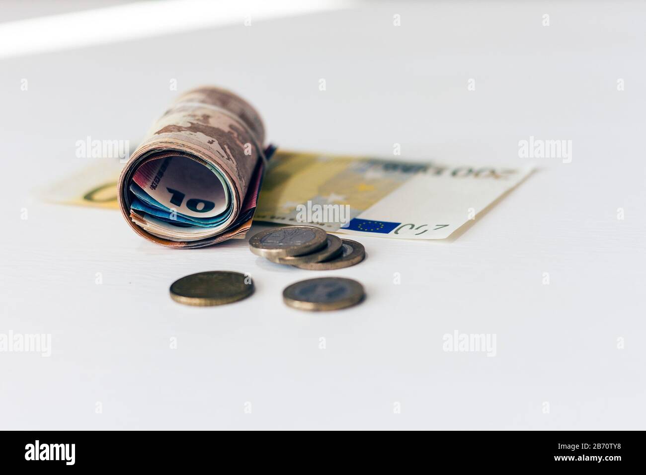 Rolled up money euro banknotes and coins on white background Stock ...