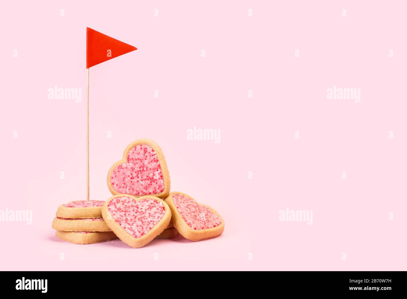Heart shape cookies with a red flag on a pink background Stock Photo ...