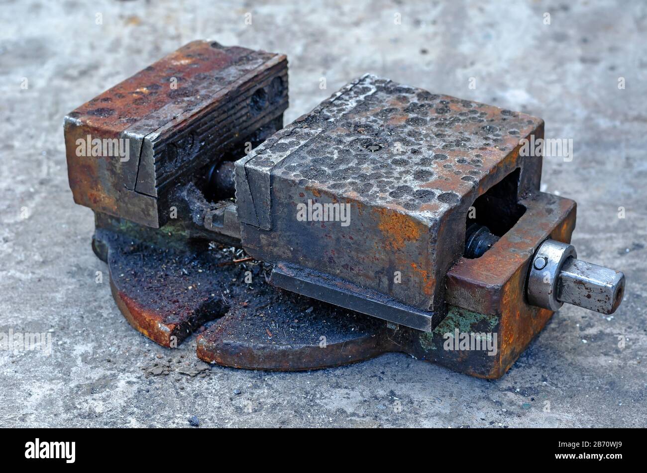 Old rusty vise on concrete. Massive vice from the milling machine ...