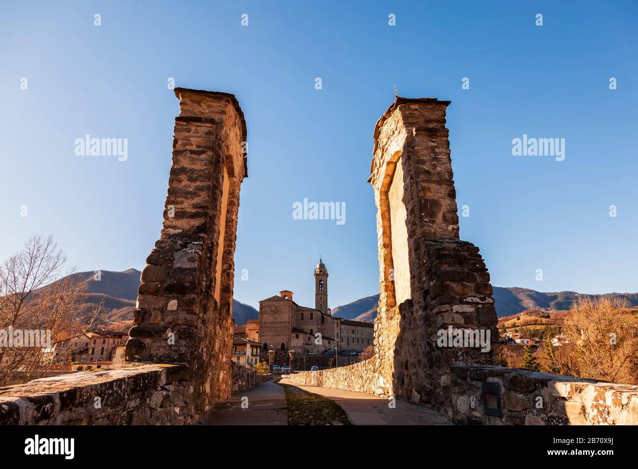 landscape of a medieval village seen from an ancient stone bridge at ...