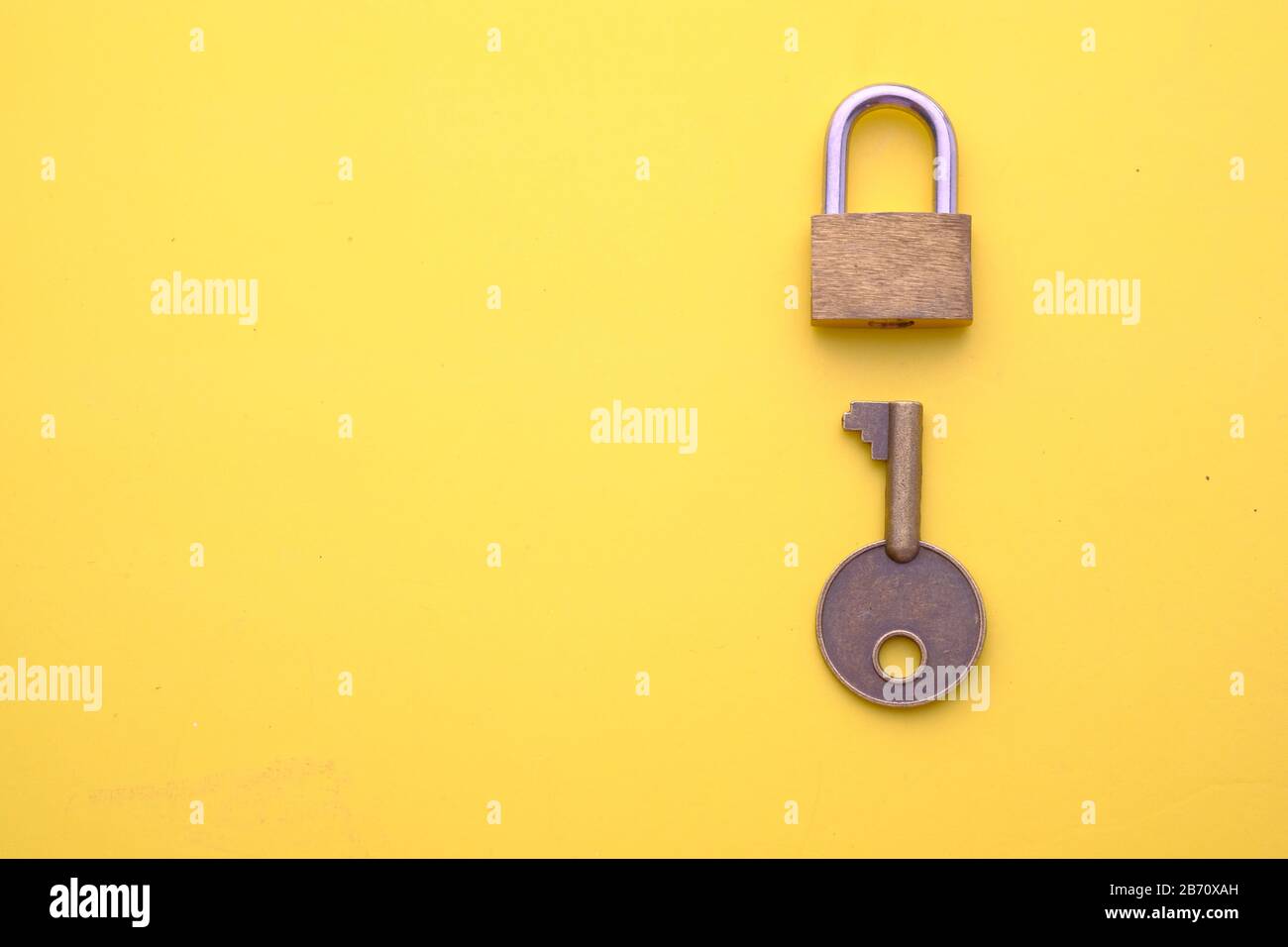 top view of padlock and key on yellow background Stock Photo - Alamy