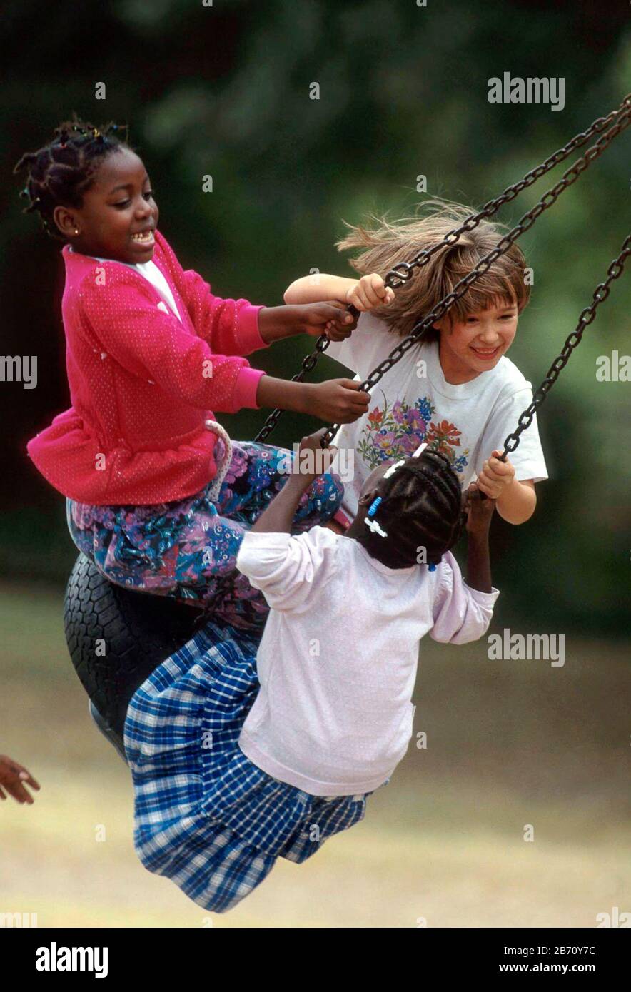 Austin, Texas: Second- and third-grade students play on a tire swing on ...