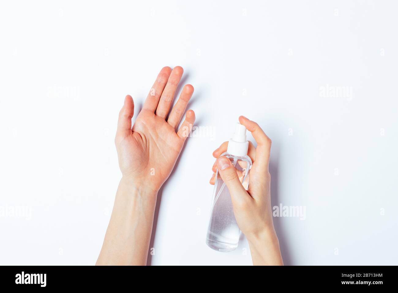 Woman's hands applying alcohol disinfectant spray on skin to avoid ...