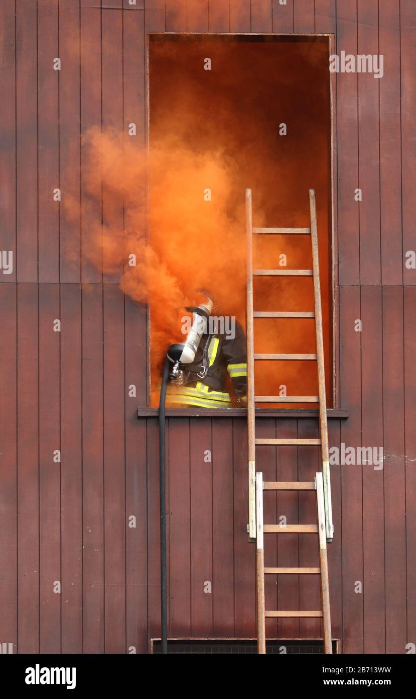firefighter enters the building full of toxic orange smoke with the ...