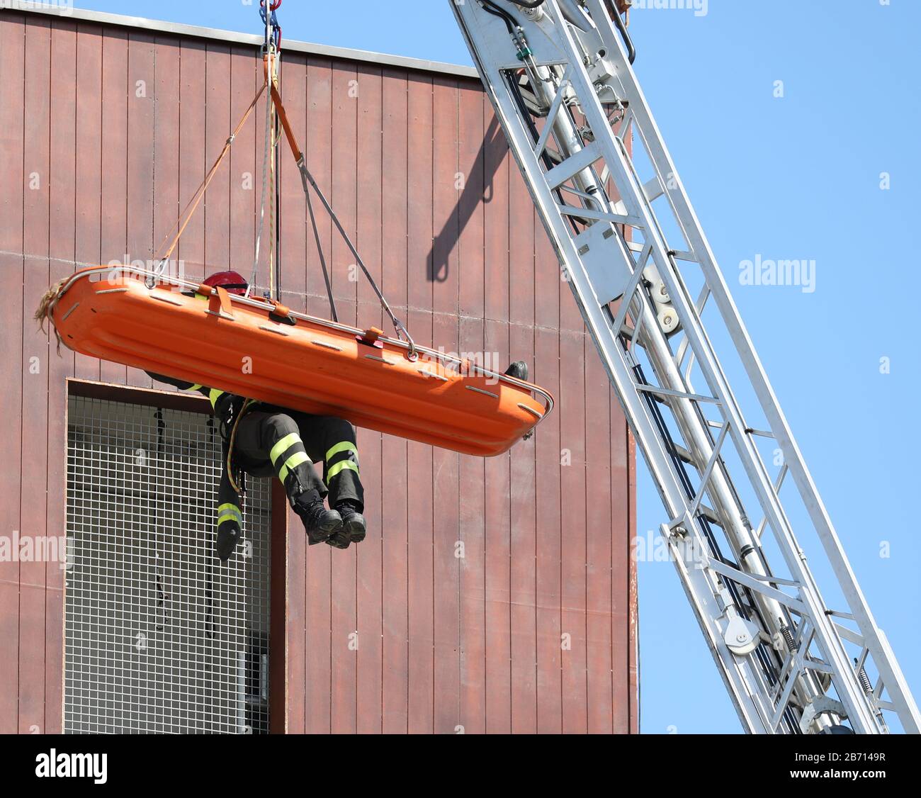 brave firefighter on the stretcher with person during an emergency ...
