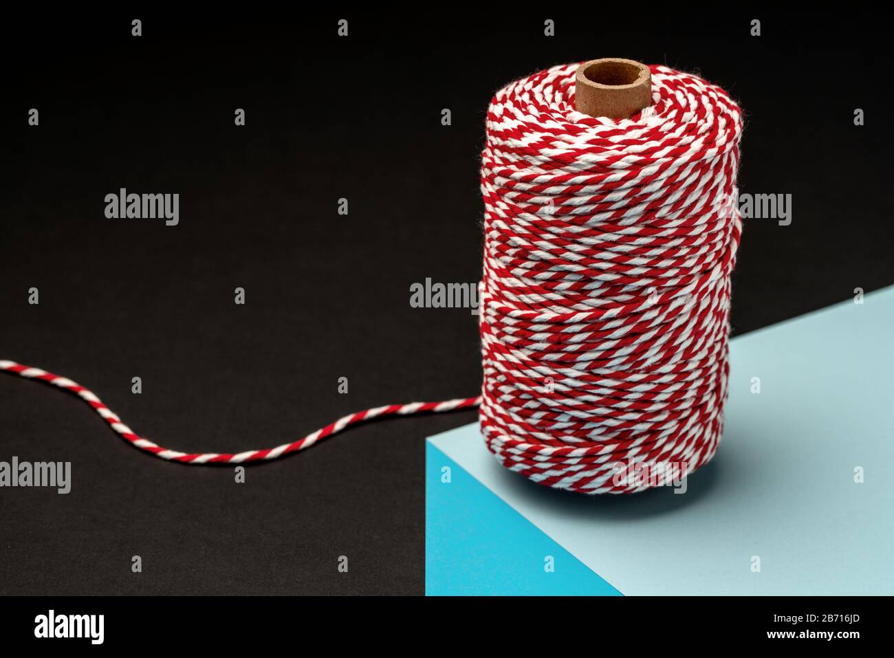 Conceptual image of a roll of rope on cube, copy space background. On a ...