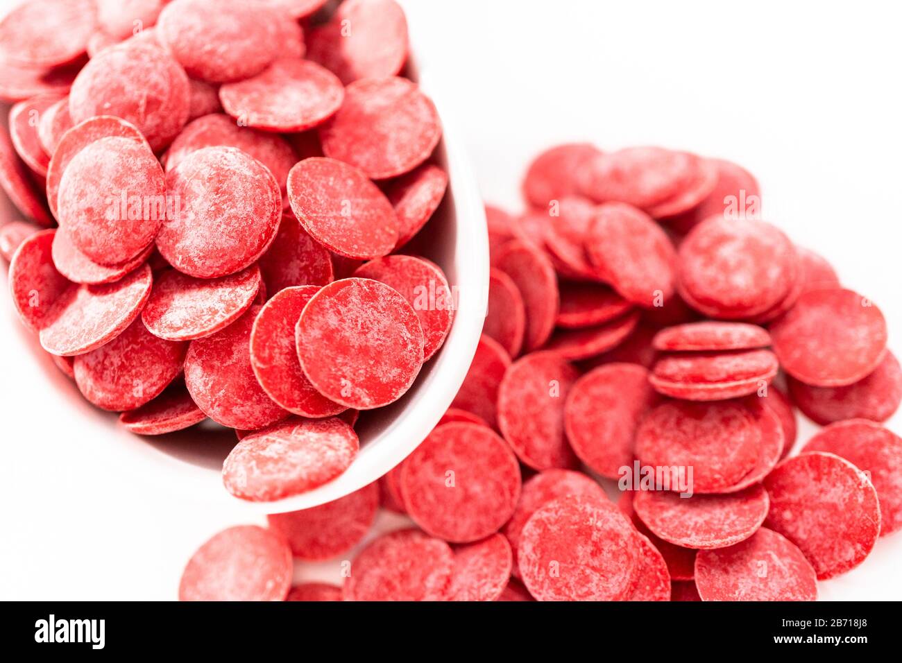 Red round chocolate chips for melting chocolate shapes on a white ...