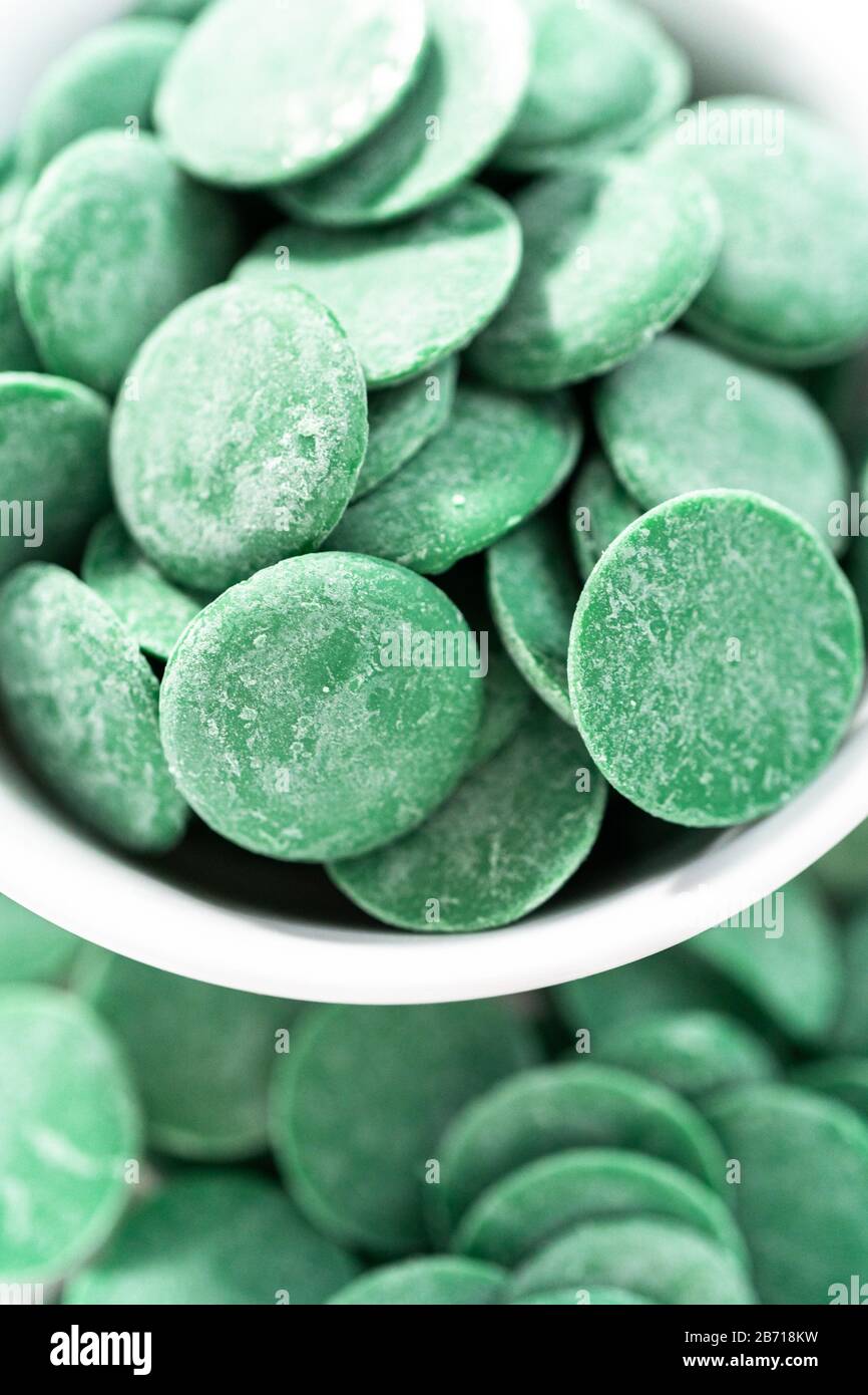 Green round chocolate chips for melting chocolate shapes on a white ...
