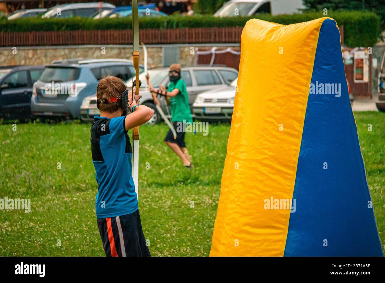 Boy attacking his opponent in a game of archery tag Stock Photo - Alamy