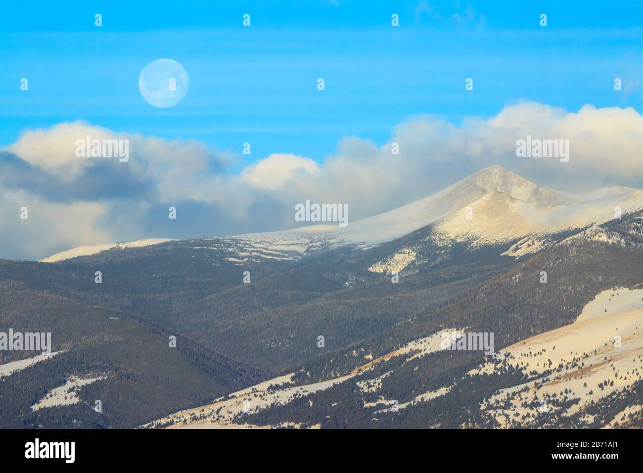 full moon setting behind mount powell in the flint creek range near ...