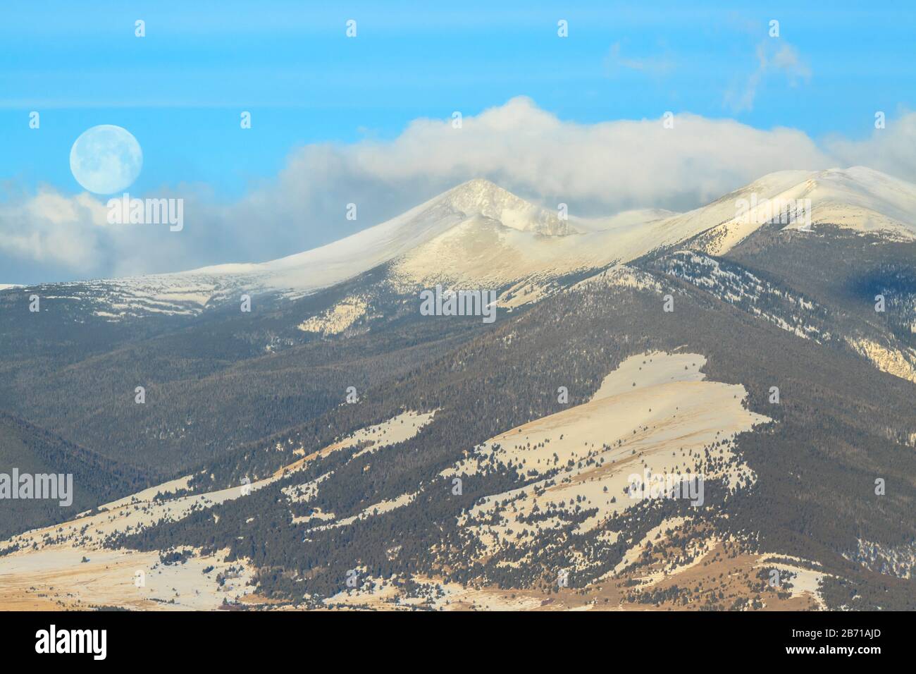full moon setting behind mount powell in the flint creek range near ...
